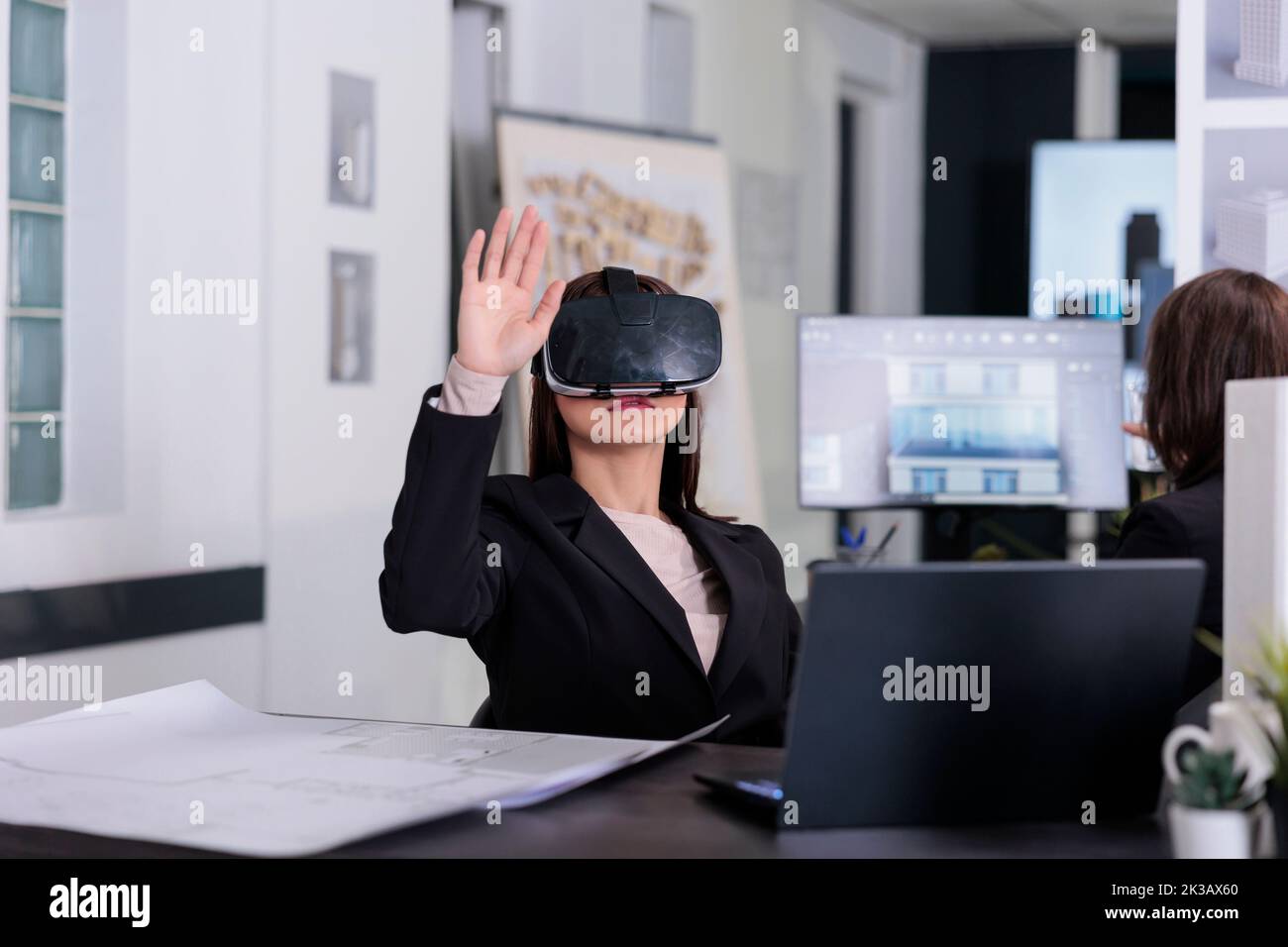 Architect working on project blueprints wearing vr helmet in ...