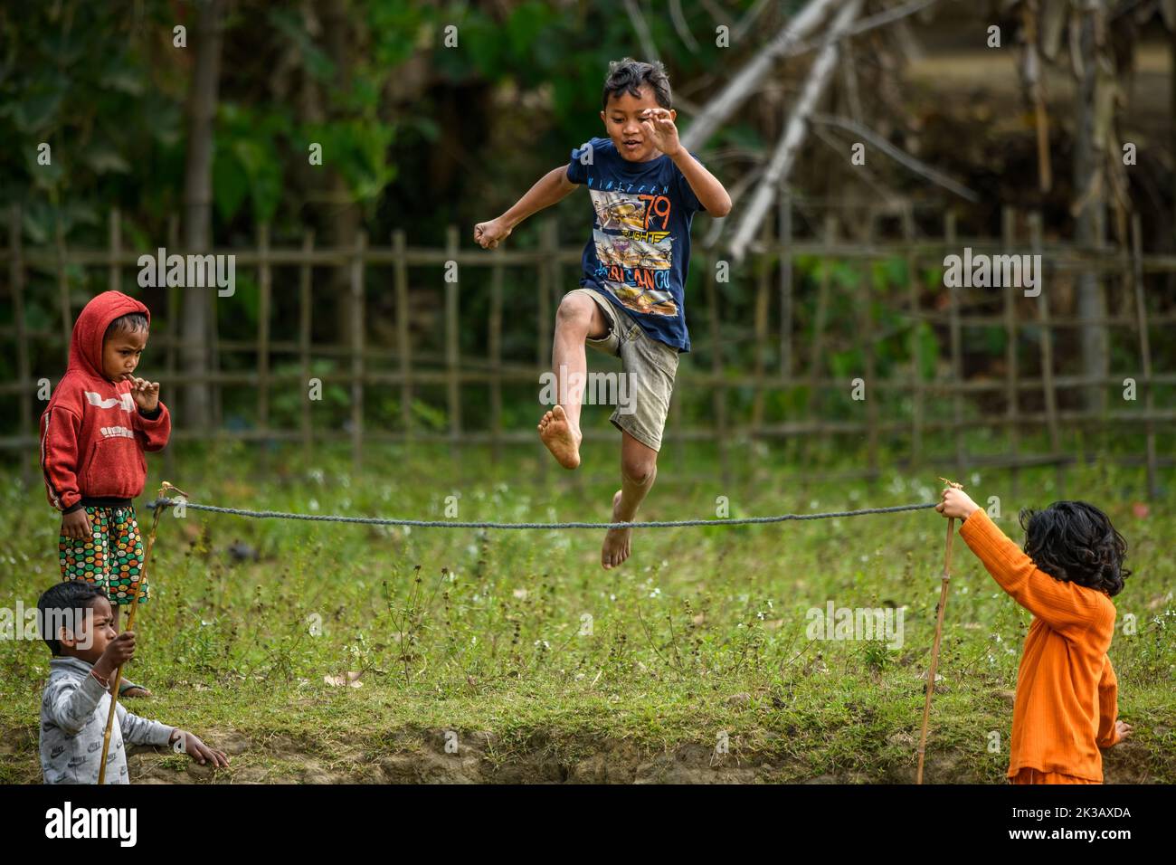 Village kids playing by the edge of a paddy field in Bokakhat village ...