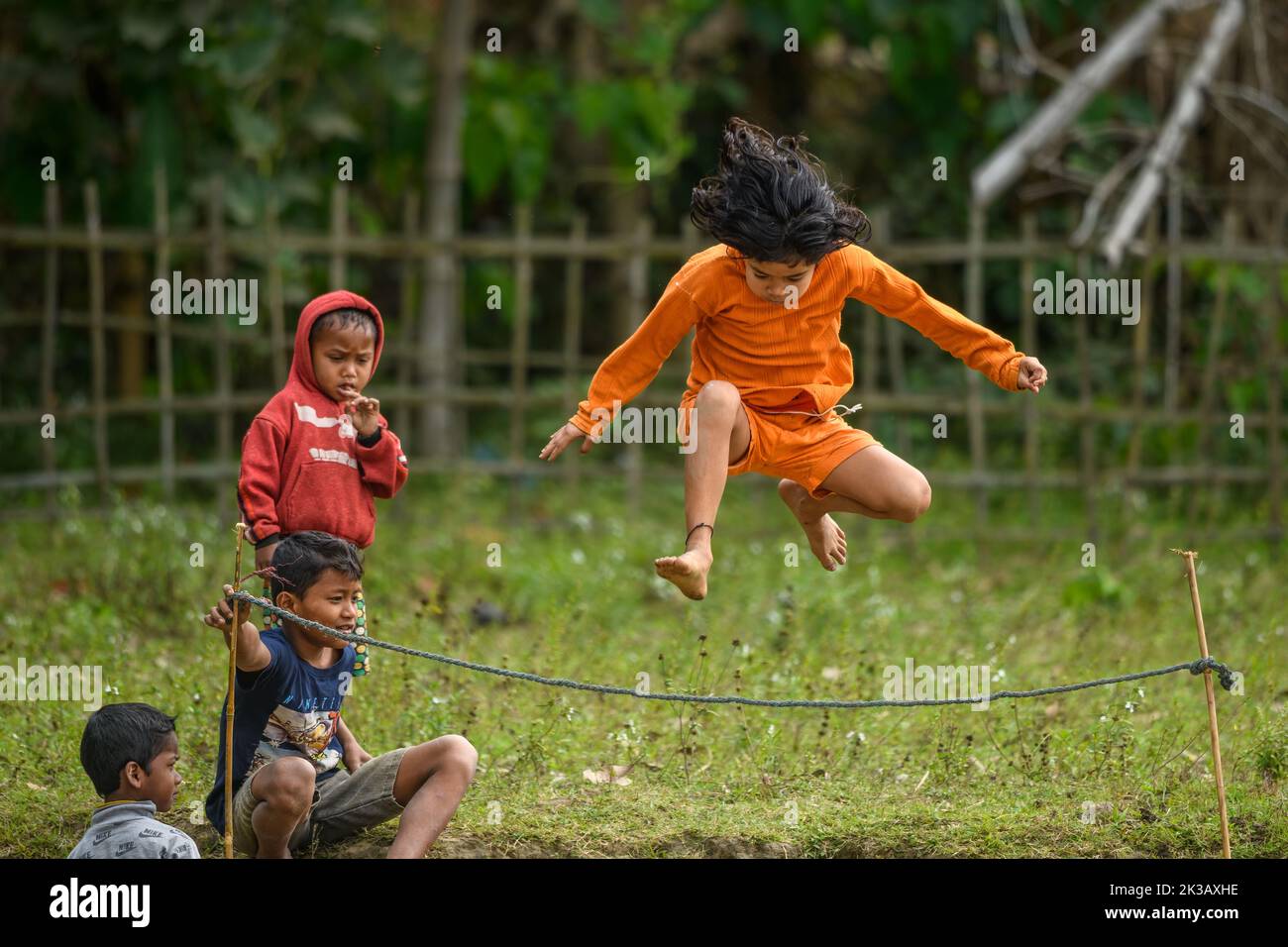Village kids playing by the edge of a paddy field in Bokakhat village ...