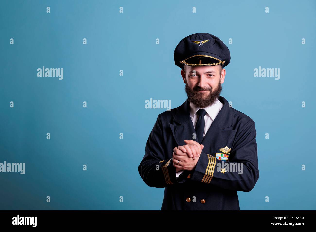 Smiling excited plane aviator in professional uniform clapping hands ...