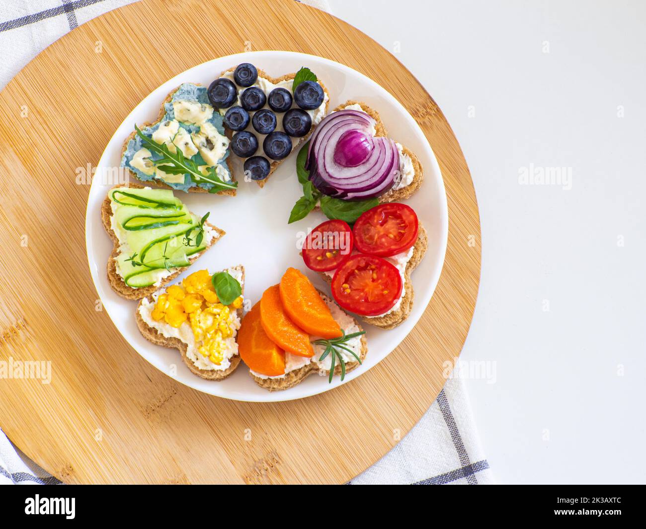 Rainbow sandwiches heart shape on white table. Breakfast bread rainbow ...
