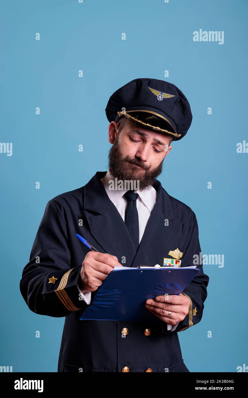 Airplane pilot holding clipboard, filling form, concentrated aviator ...