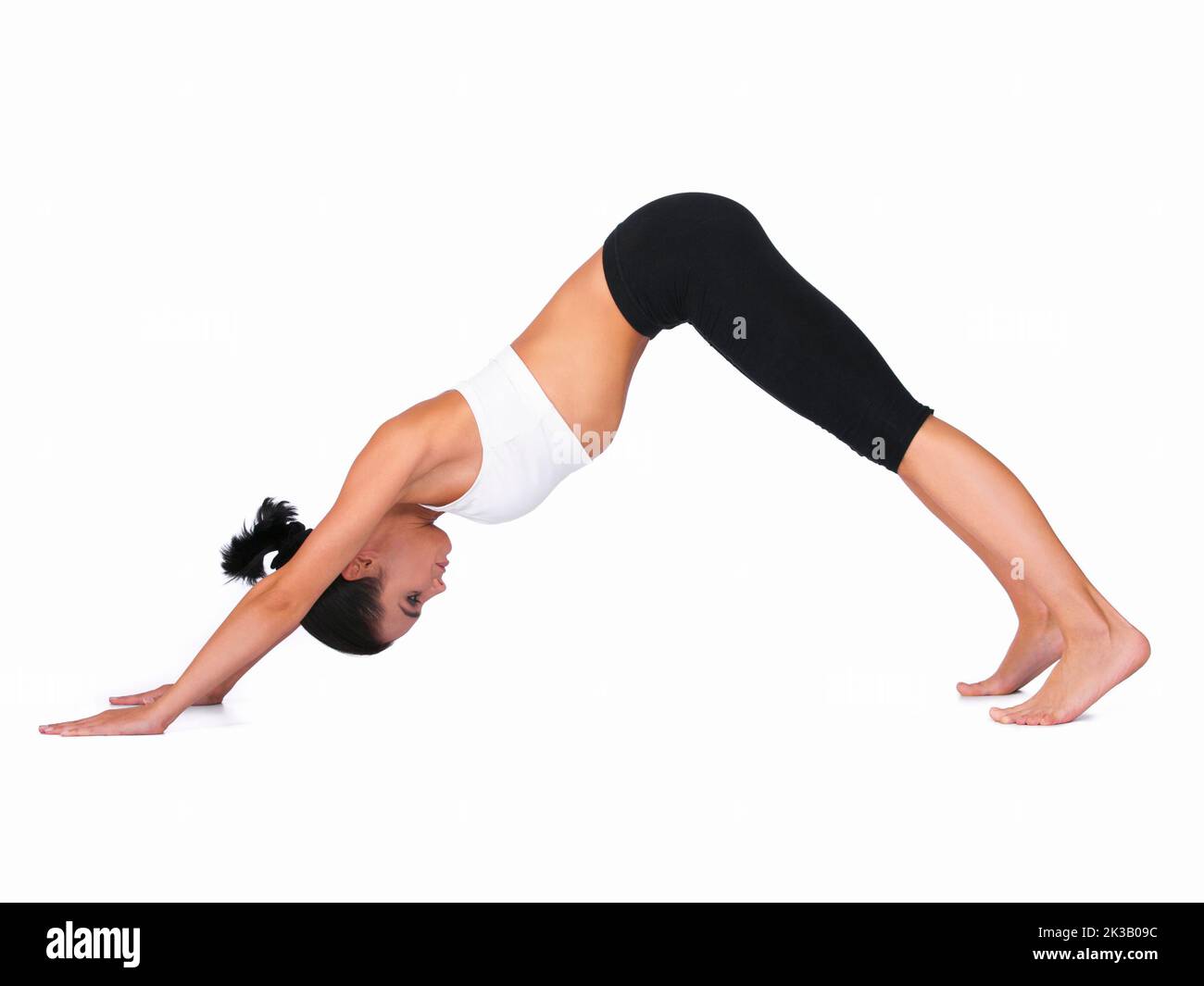 Going into downward-facing dog. A young woman doing stretches while ...