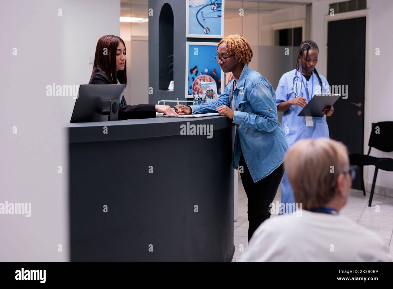 African american patient filling in report papers, talking to ...