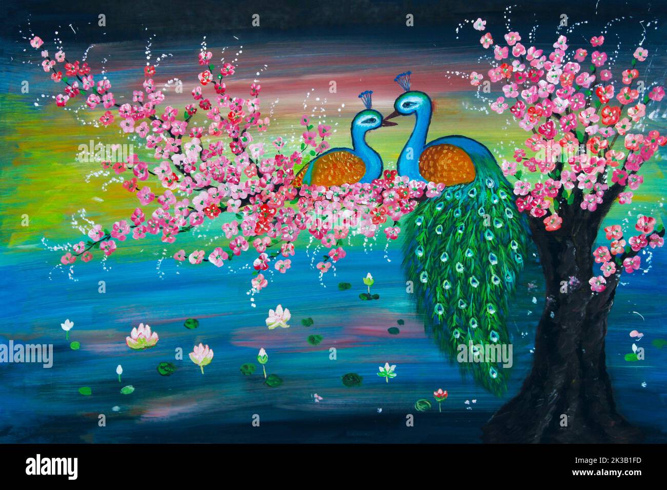 Two peacocks sitting together on flowering pink branch over pond filled ...