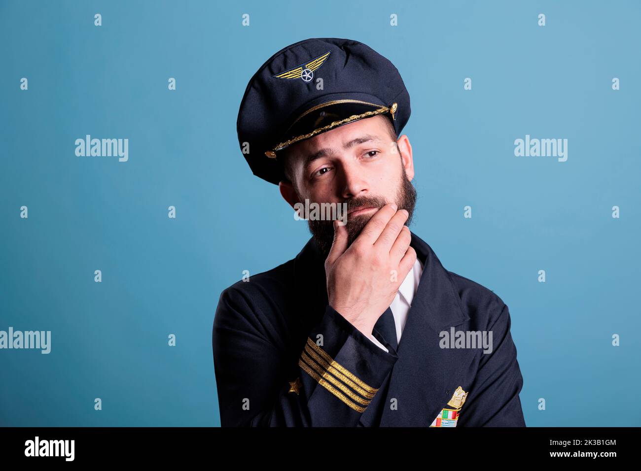 Pensive thoughtful airline capitan in uniform questioning, making ...