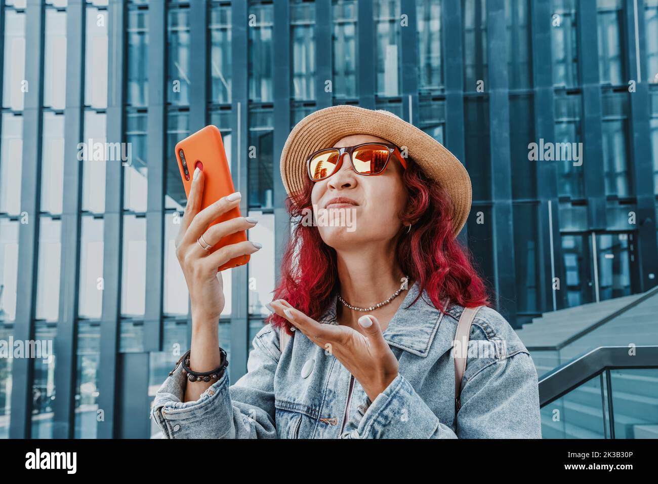 Annoyed girl unsuccessfully tries to catch a cellular signal or an ...