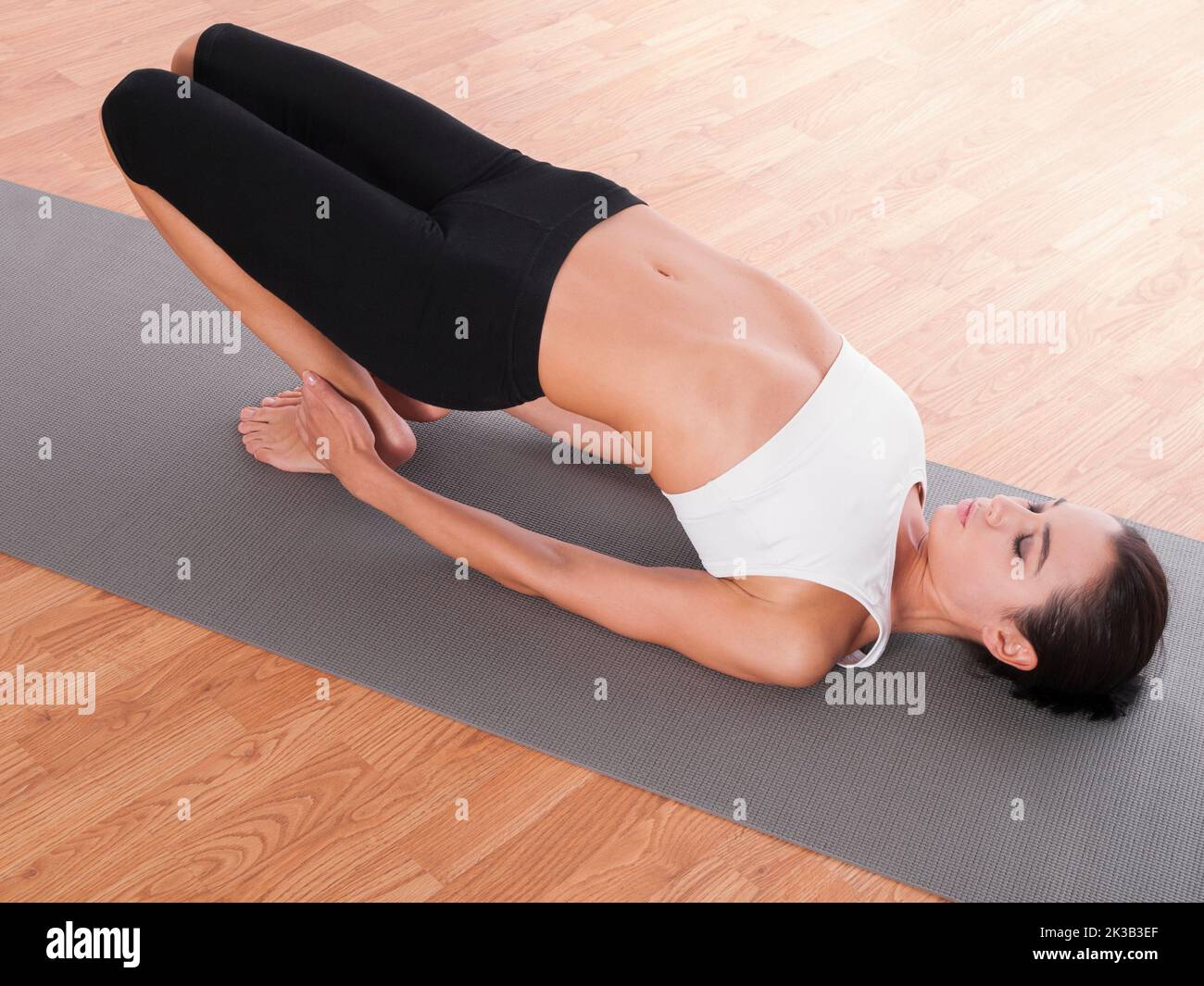 Beautifully balanced. a beautiful young woman doing yoga on an exercise ...