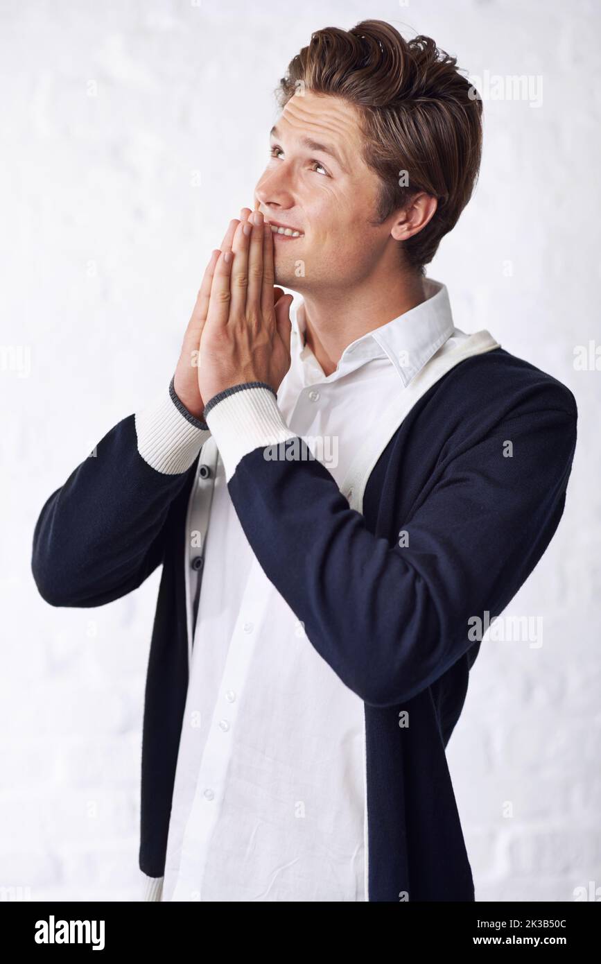 Please make it happen. a handsome young man praying for some good luck ...