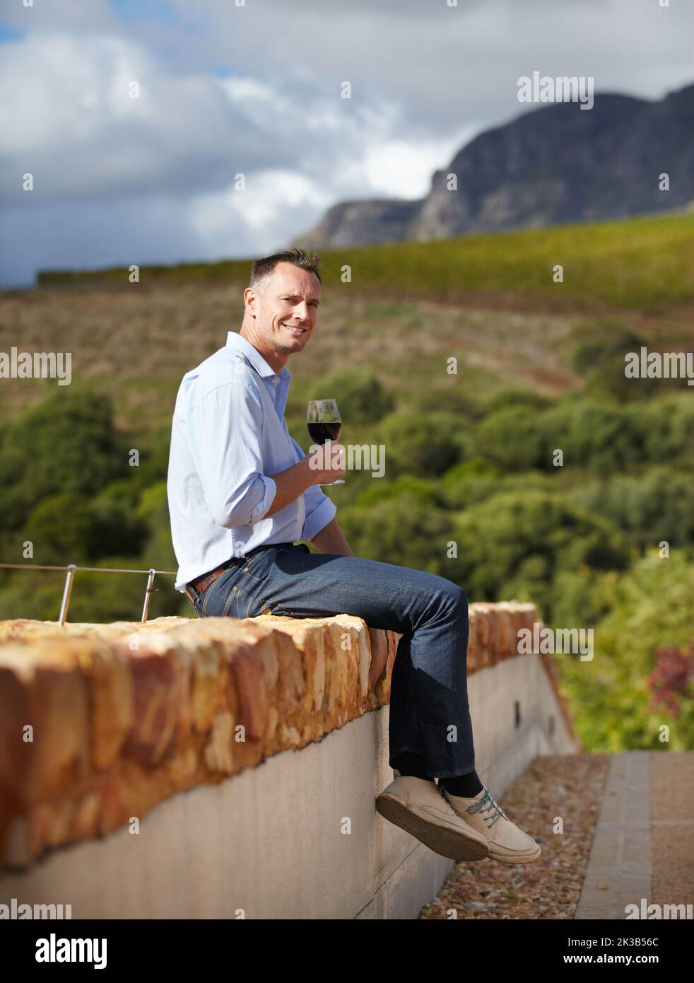 Just taking it easy. Portrait of a mature man sitting on wall and ...