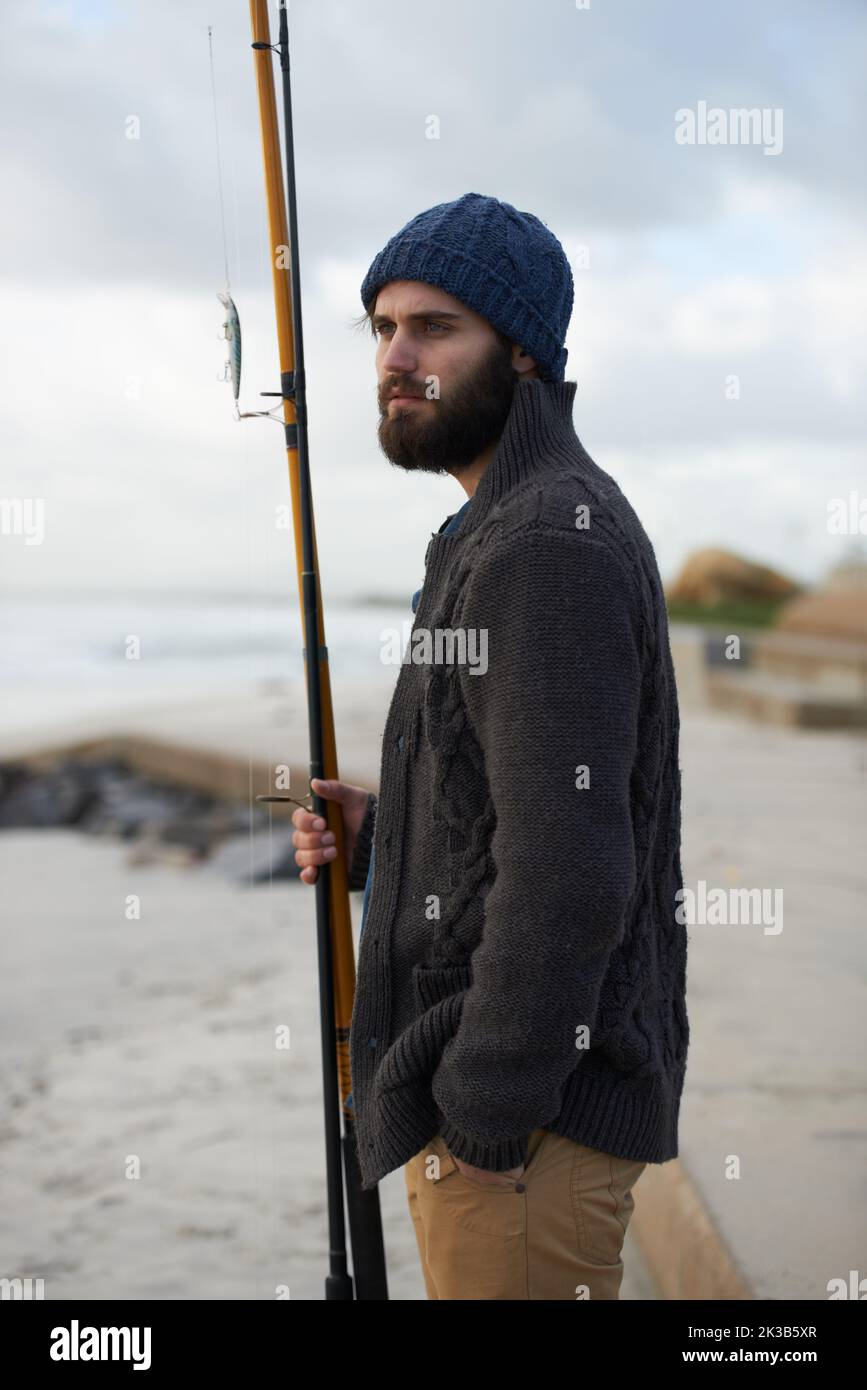 The early bird catches the worm. a young fisherman holding a fishing ...