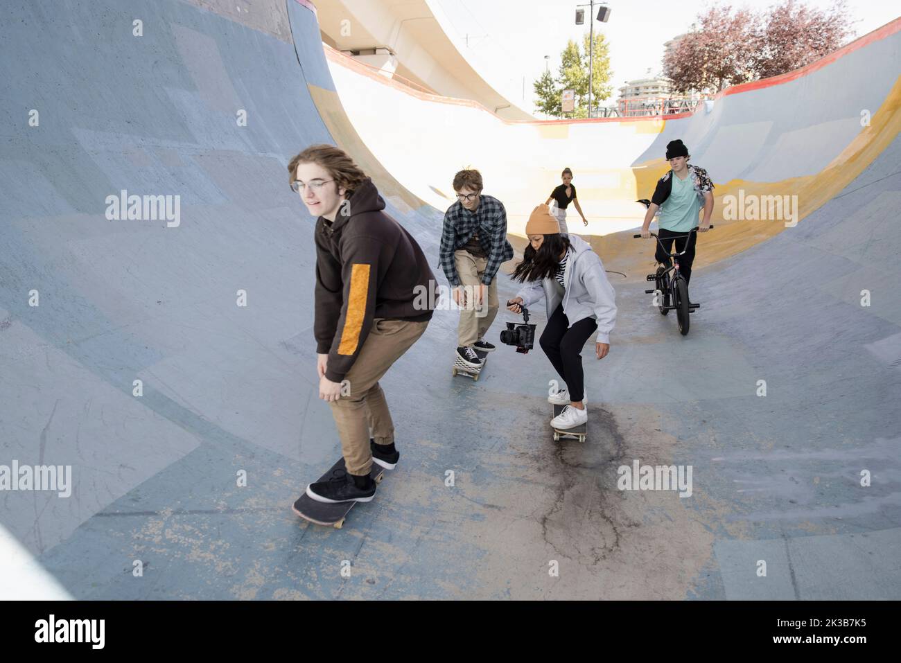 Asian skater filming friends on skateboard in tunnel Stock Photo - Alamy