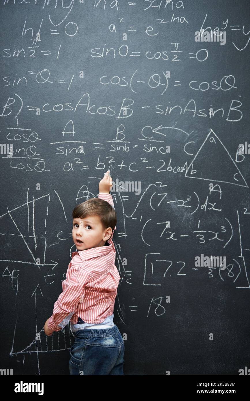 What a little genius. Studio shot of a young boy with a blackboard full ...
