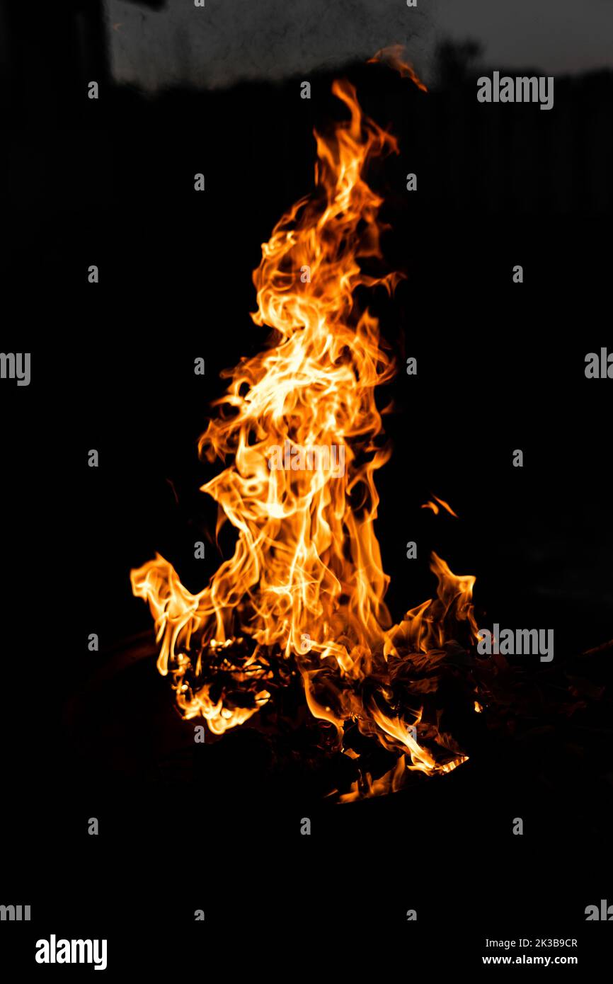 A vertical shot of orange and yellow burning fire in the dark Stock ...