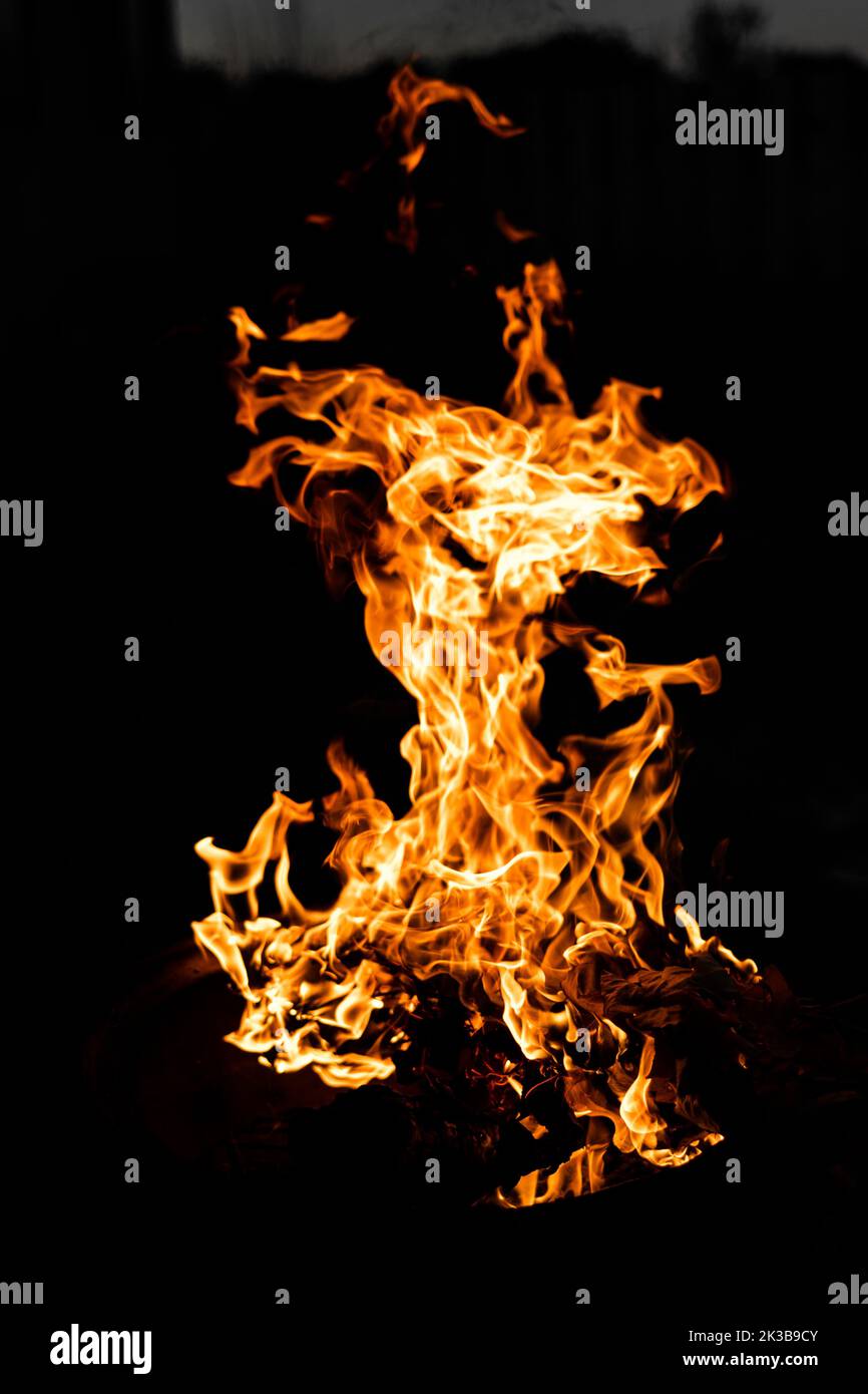 A vertical shot of orange and yellow burning fire in the dark Stock ...