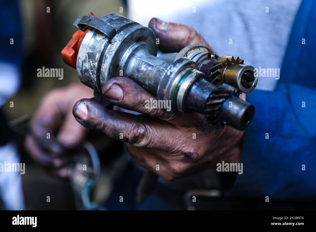 A closeup shot of mechanician hands holding two ignition distributor ...