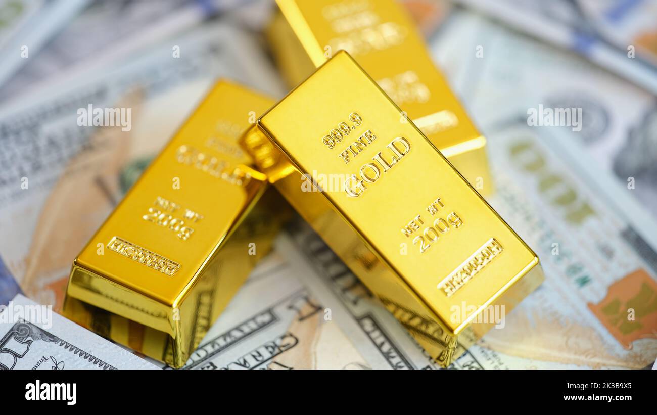 Gold bars on background of US dollars banknotes Stock Photo - Alamy