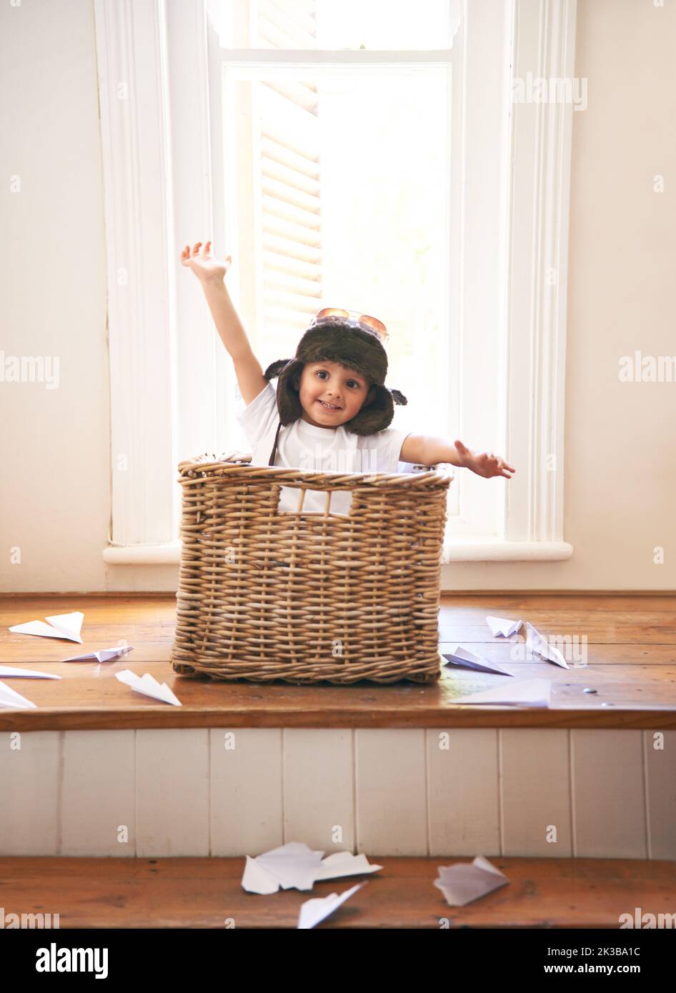 Reach for the sky. an adorable little boy sitting playing in a basket ...