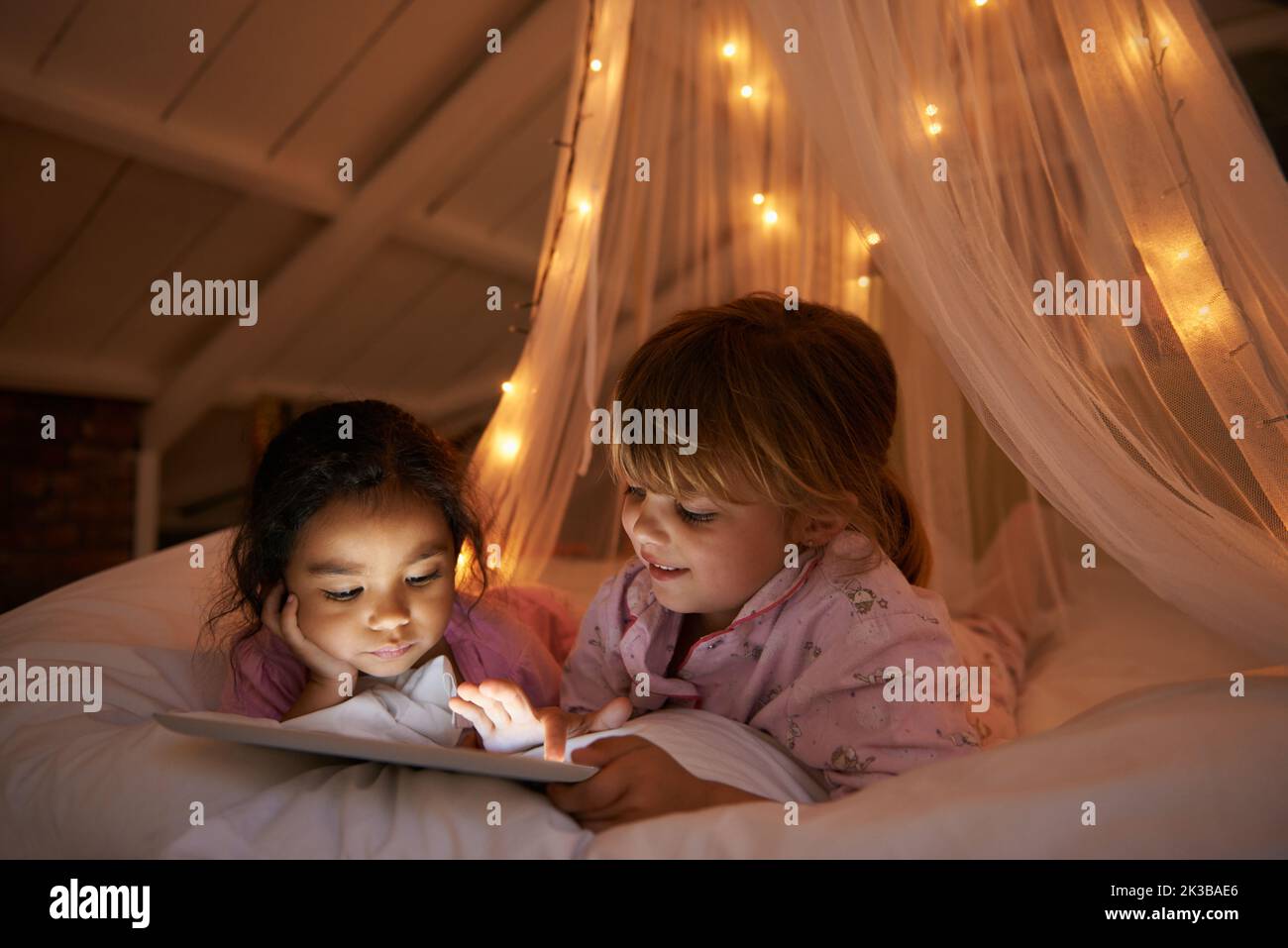 I LOVE sleepovers. two little girls reading together during their ...