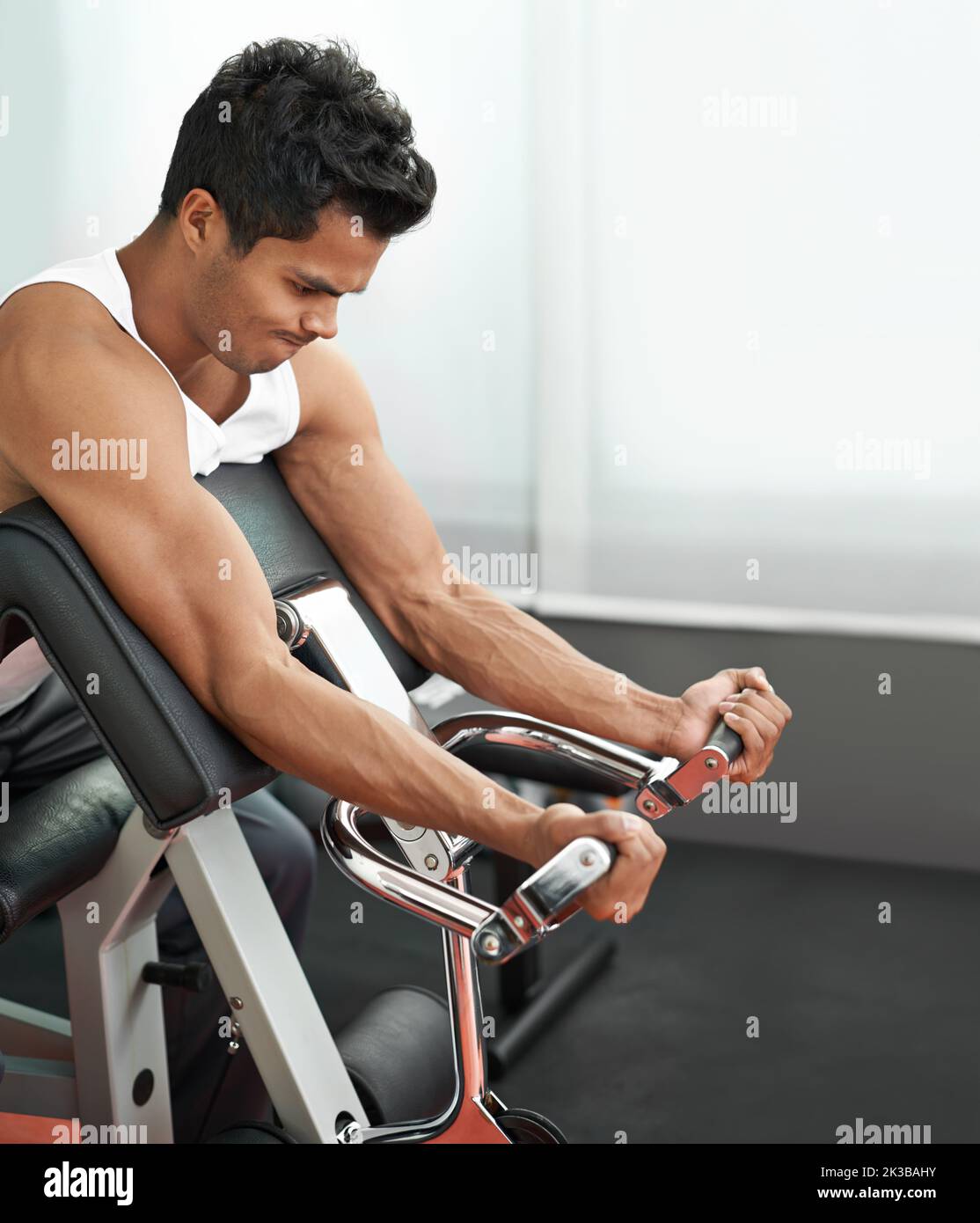 Focused on his stamina. A young ethnic man working out his arm muscles ...