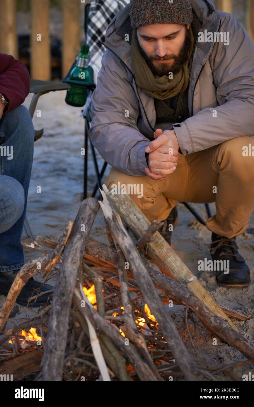 Camping out on the beach. A young man making a fire on the beach Stock ...