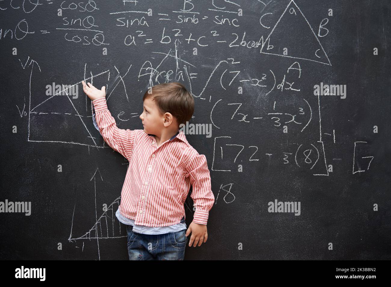 What a little genius. Studio shot of a young boy with a blackboard full ...