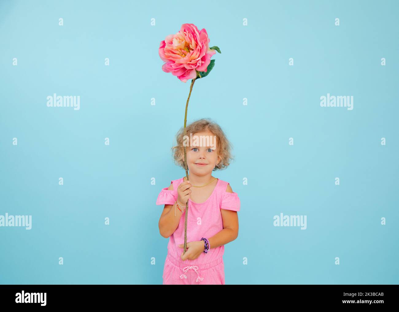 Portrait of smiling little girl hold raising hand with huge artificial ...