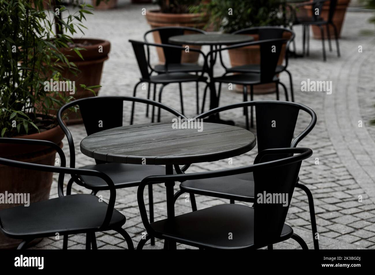 empty black tables and chairs of restaurant. bistro terrace on street ...