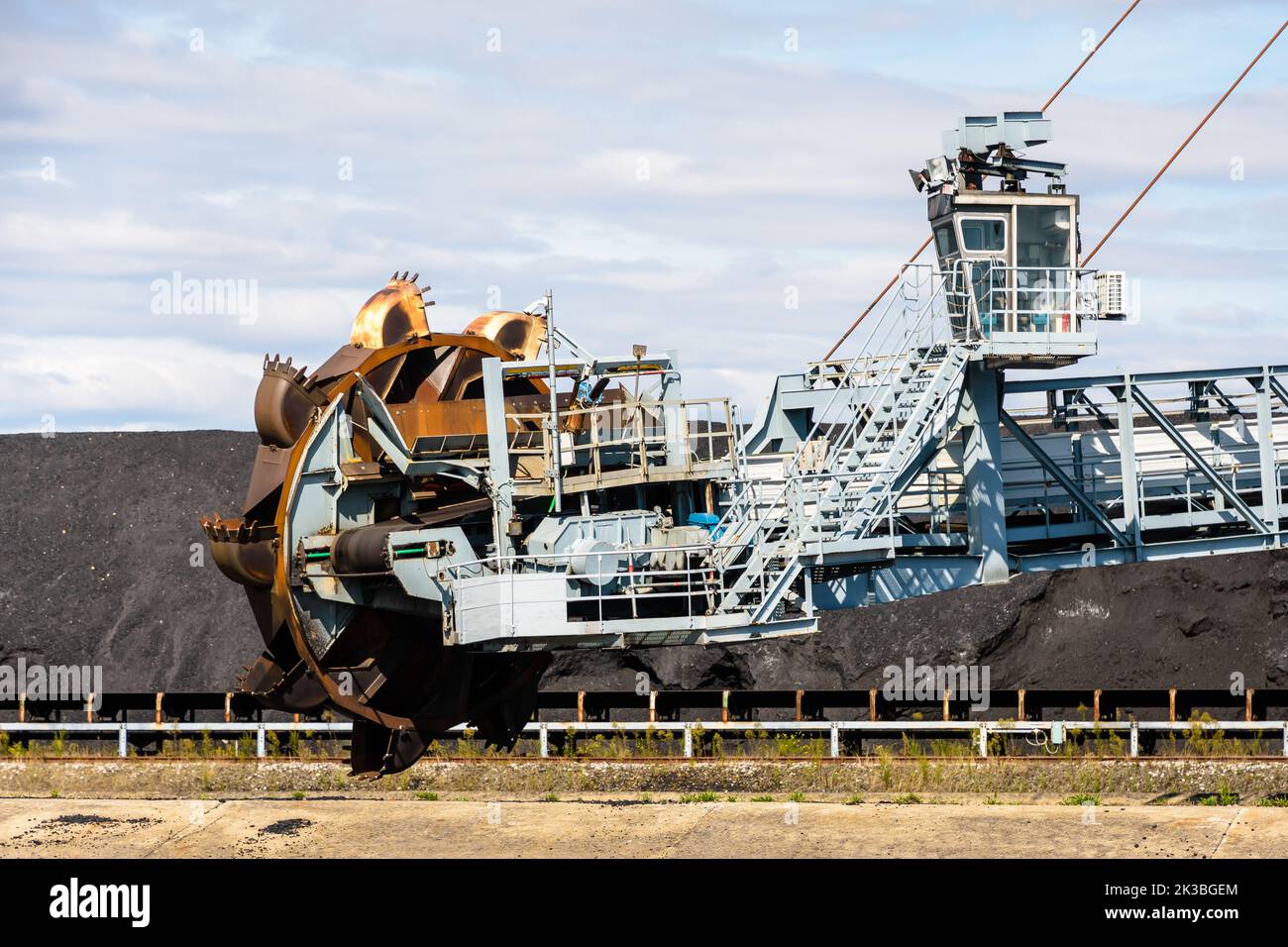Close-up view of a bucket-wheel stacker-reclaimer and a coal stockpile ...