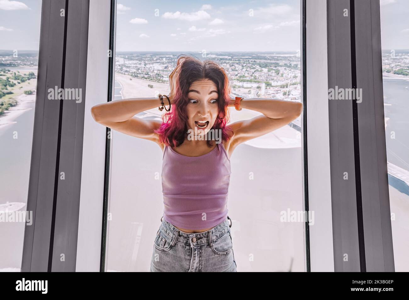 A girl with a phobia and fear of heights screams and reacts emotionally ...