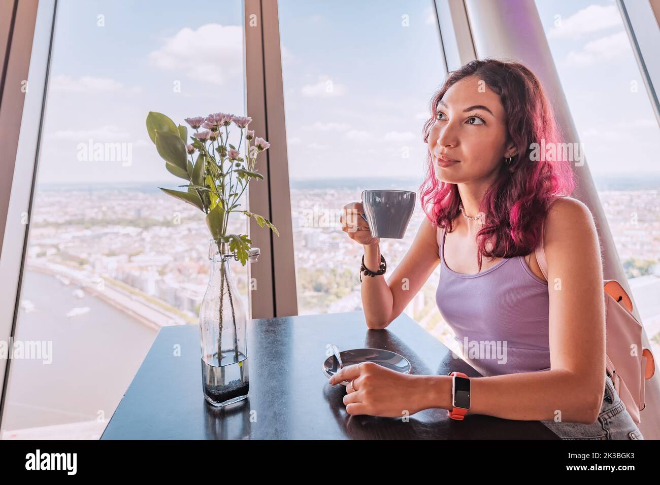 Happy girl drinking coffee in a cafe and admires out of the window on ...