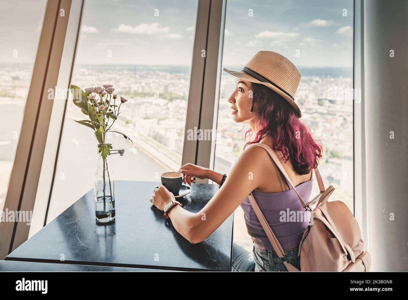 Happy girl drinking coffee in a cafe and admires out of the window on ...