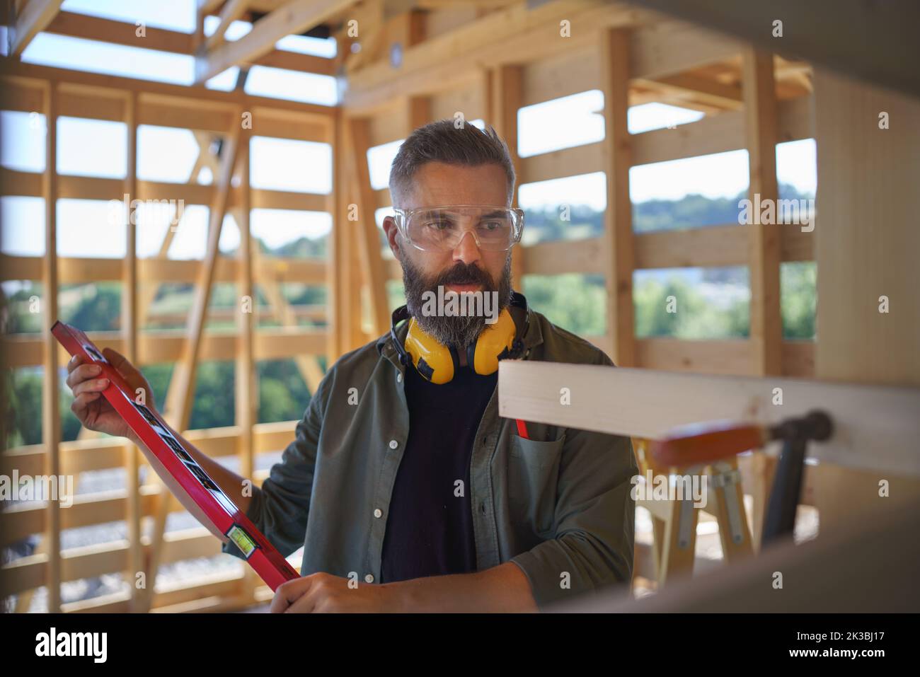 Carpenter checking wooden planks with spirit level, diy eco-friendly ...