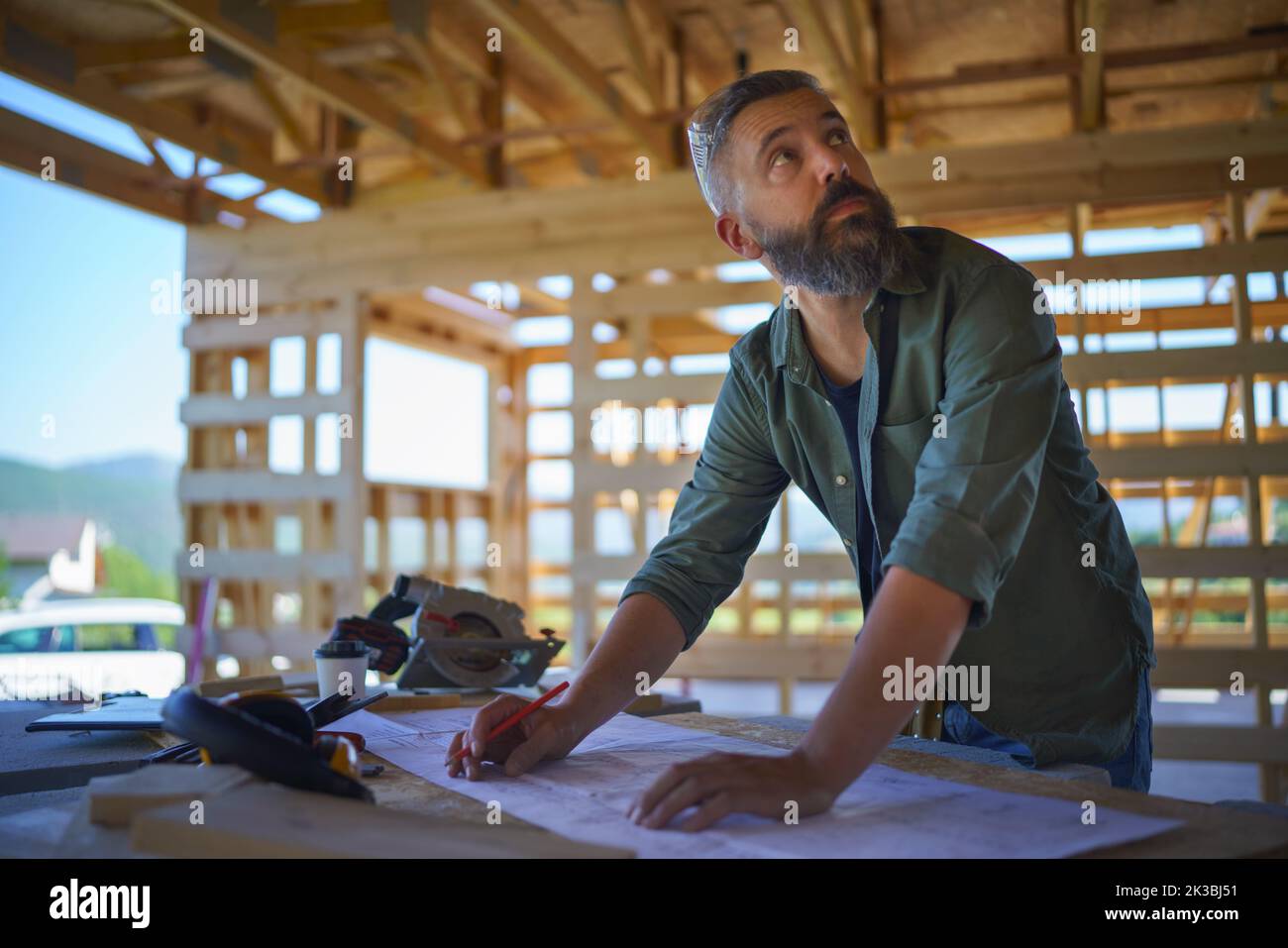 Construction worker drawing and checking blueprints, diy eco-friendly ...