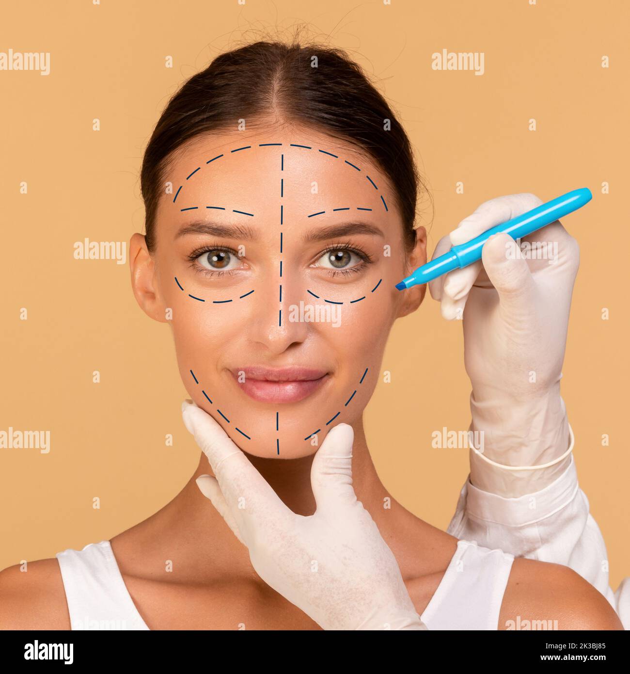 Plastic surgeon drawing marks on young woman's face for cosmetic ...