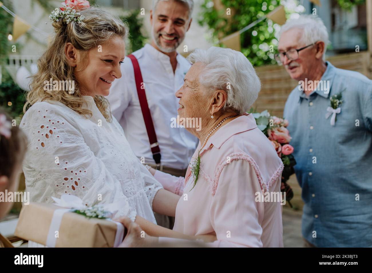 Mature bride and groom receiving congratulations at wedding reception ...
