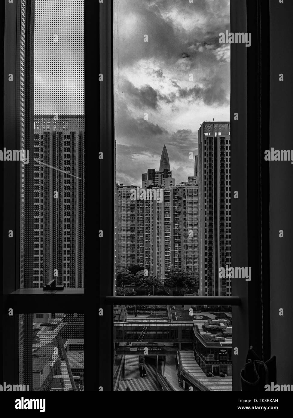 A vertical grayscale of modern buildings in the city shot through a ...
