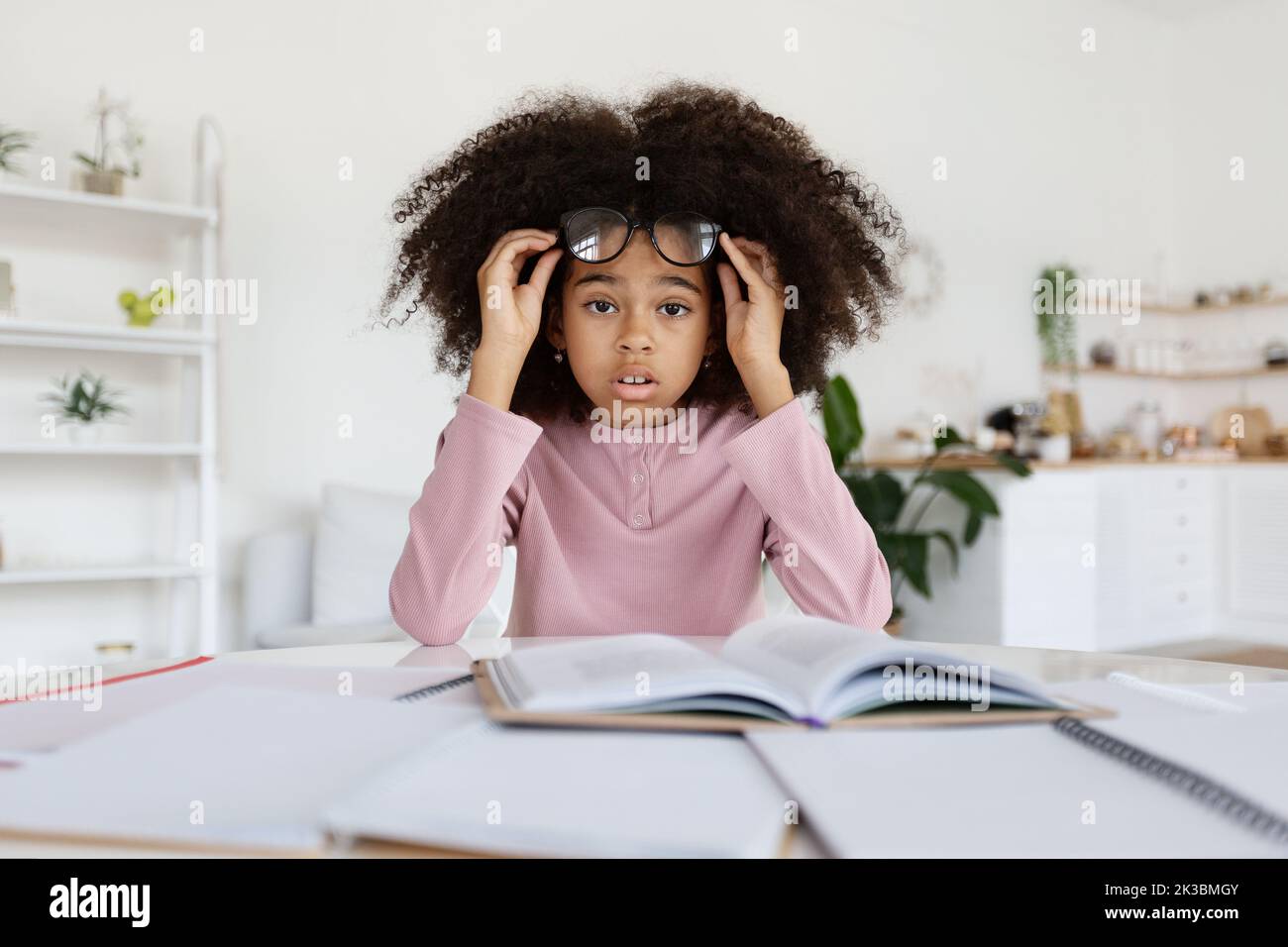 Shocked black child schooler doing homework at home Stock Photo - Alamy