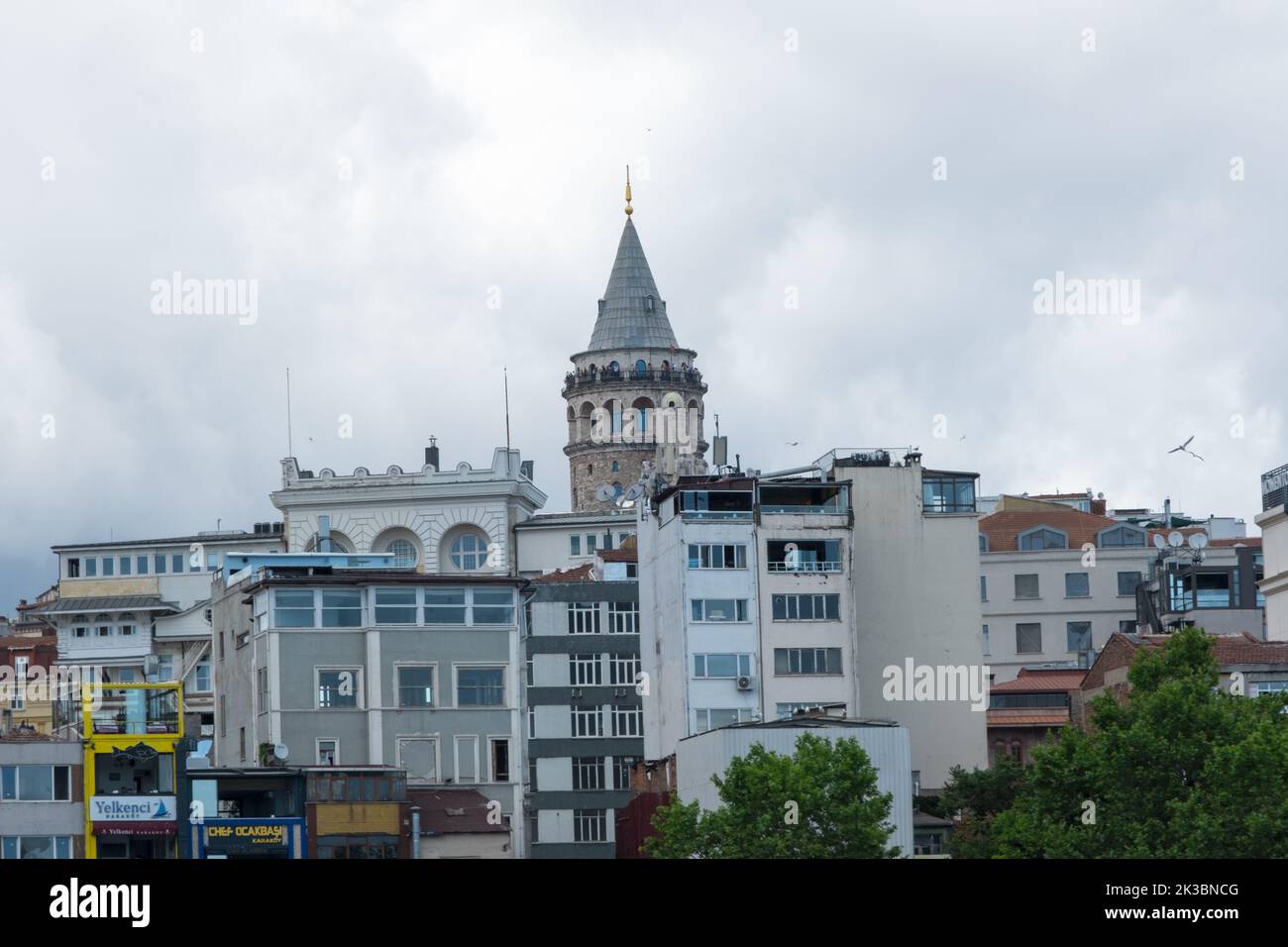 Galata Tower behind buildings front side view from Golden Horn, known ...