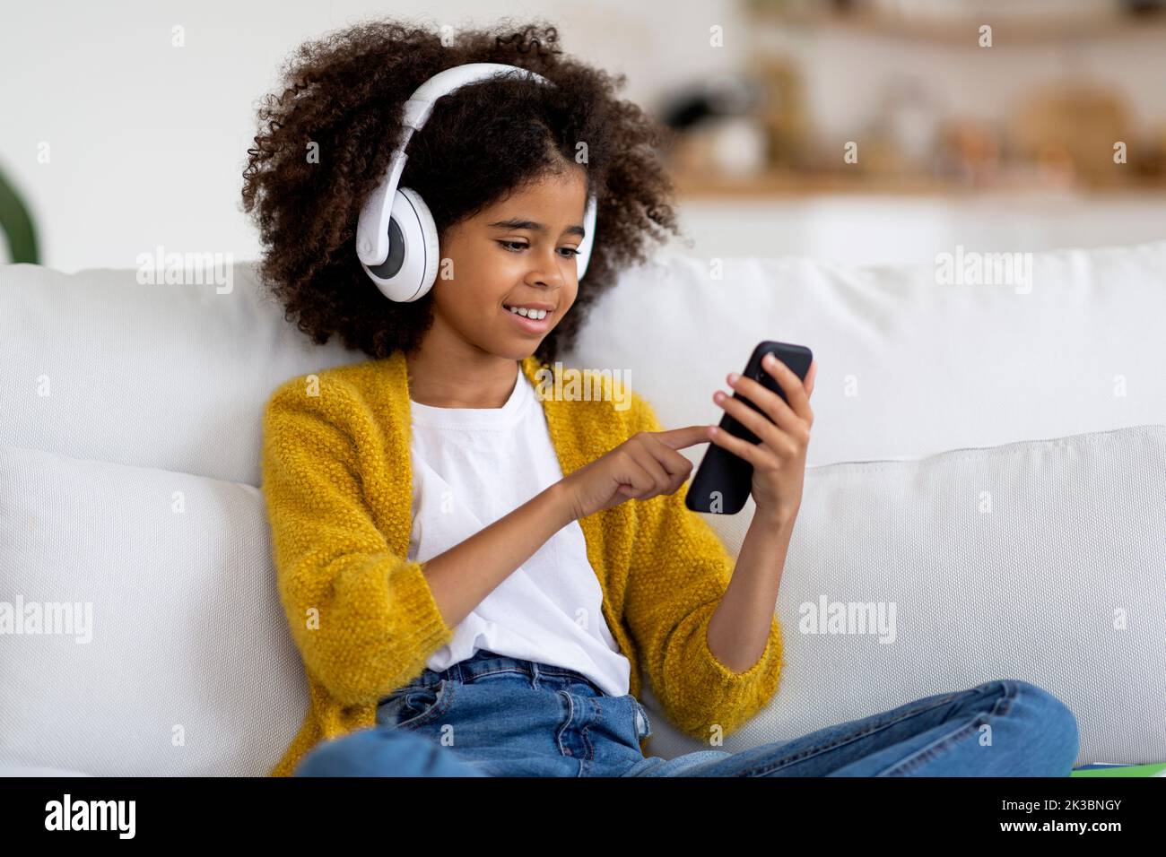 Cute black child watching video on Internet, home interior Stock Photo ...