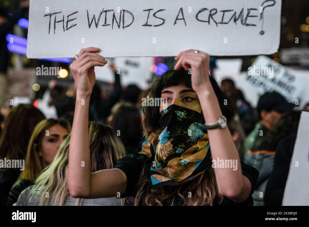 Toronto, Canada. 24th Sep, 2022. A masked woman holds a placard that ...