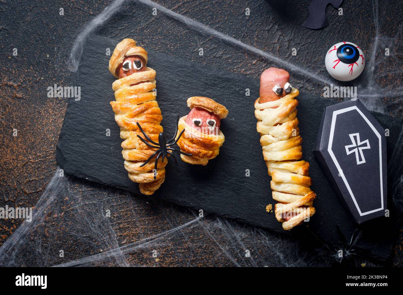 Scary Family of sausage mummies in dough in black plate with graves on ...