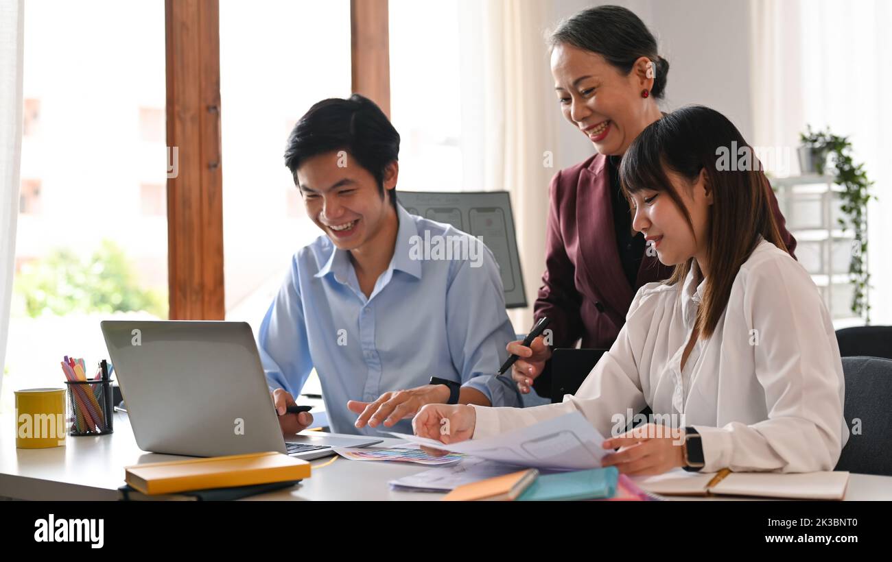 Senior manager and young creative team brainstorming, working together ...