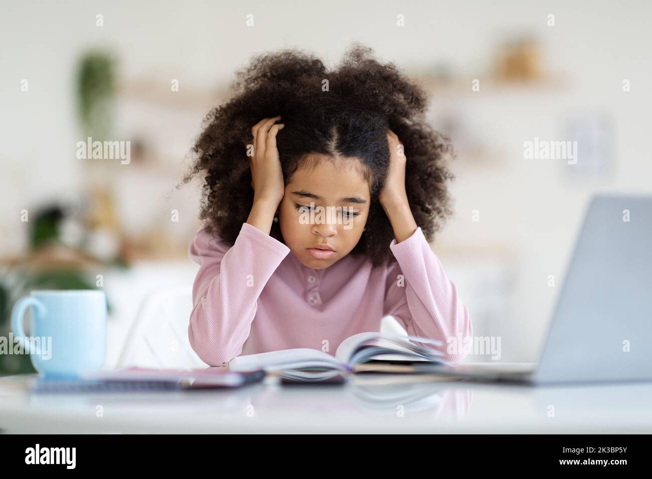 Exhausted african american child schooler doing homework Stock Photo ...