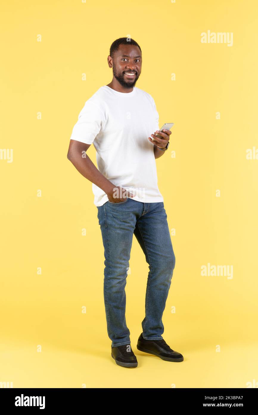 Cheerful Black Man Using Smartphone Standing On Yellow Background ...