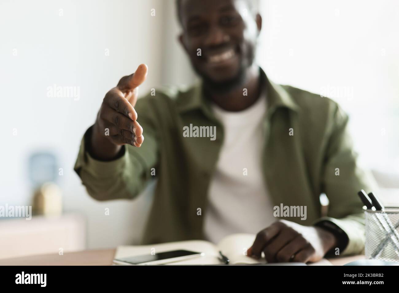 Partnership concept. Positive black man extending hand for handshake at ...