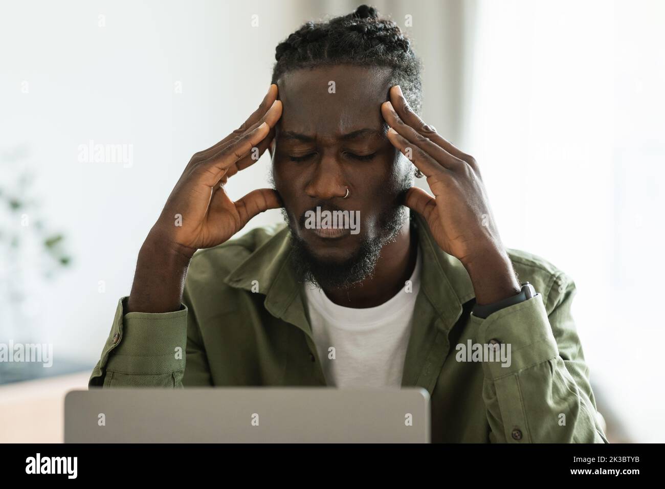 Unhappy black male freelancer touching head, suffering from headache or ...