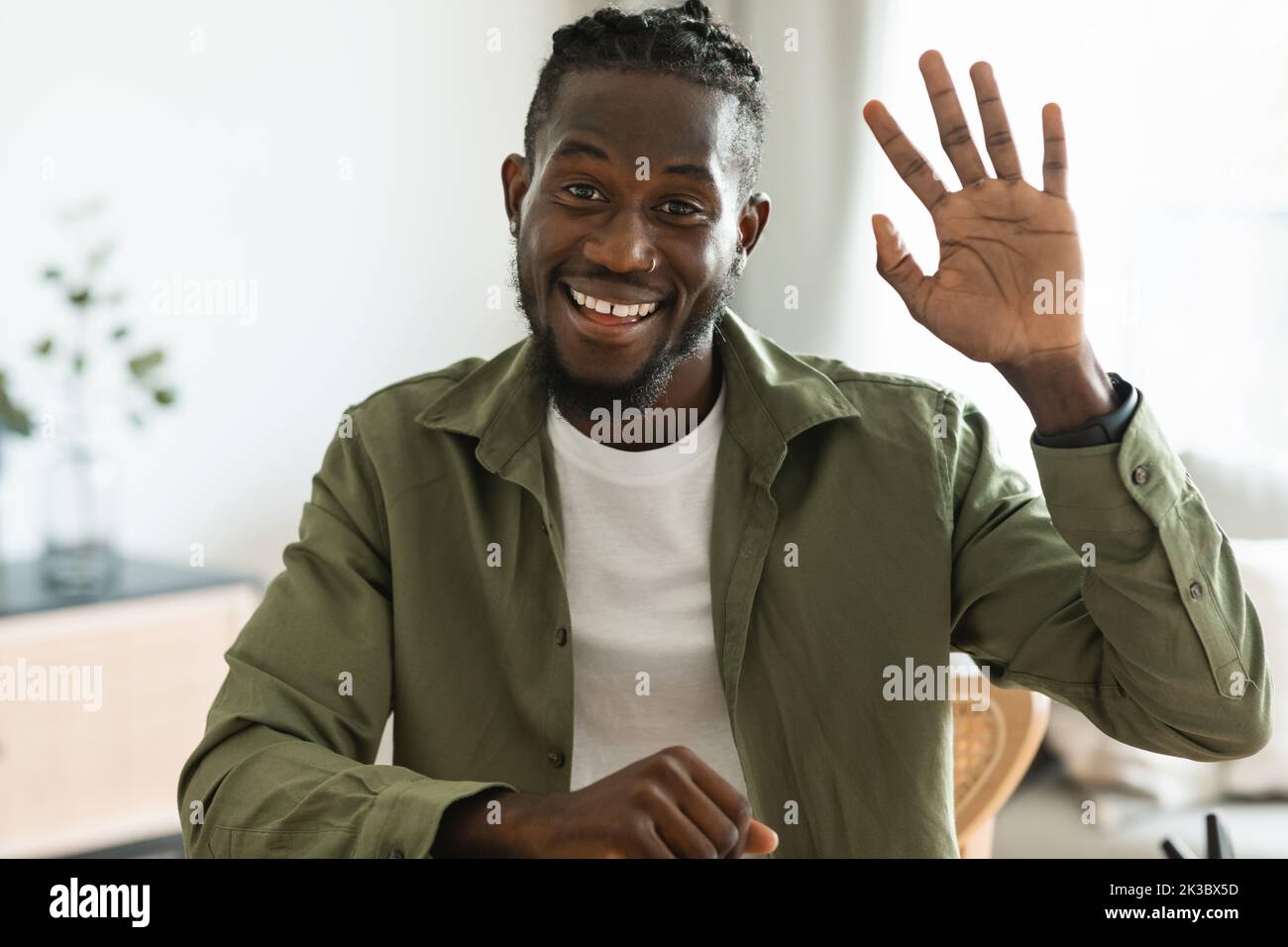 Greeting concept. Friendly black man waving at camera and smiling ...