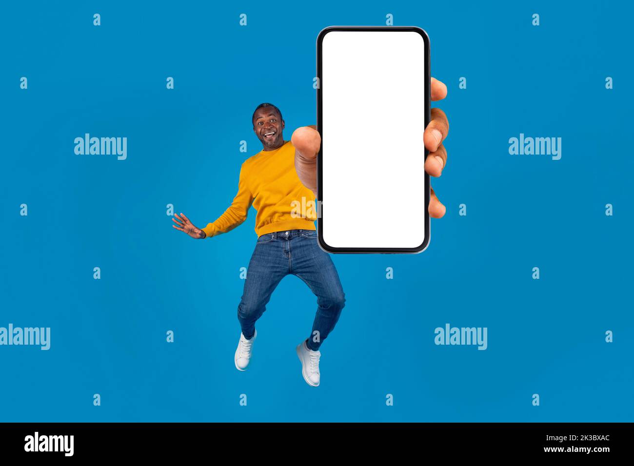 Emotional black man jumping up with cell phone, mockup Stock Photo - Alamy