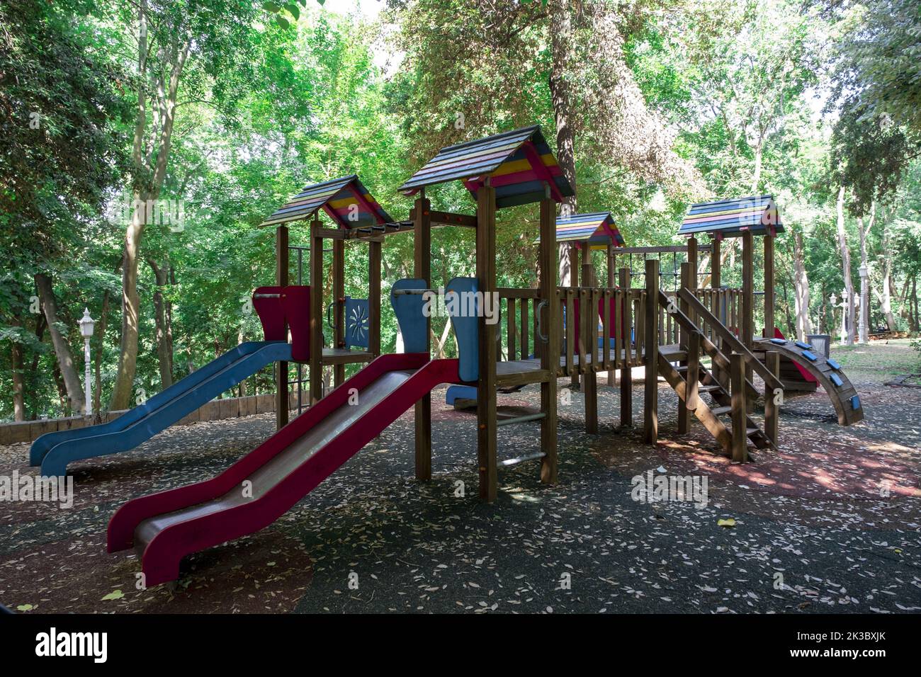 Colorful playground with slides in forest, playing field for children ...